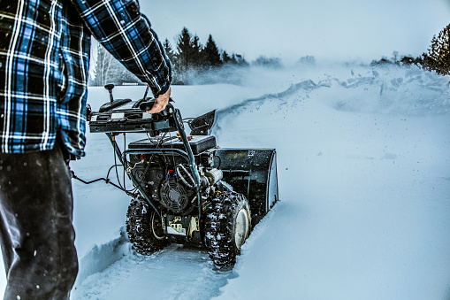 Senior man using a snowblower machine to clean snow. | Blain's Farm ...
